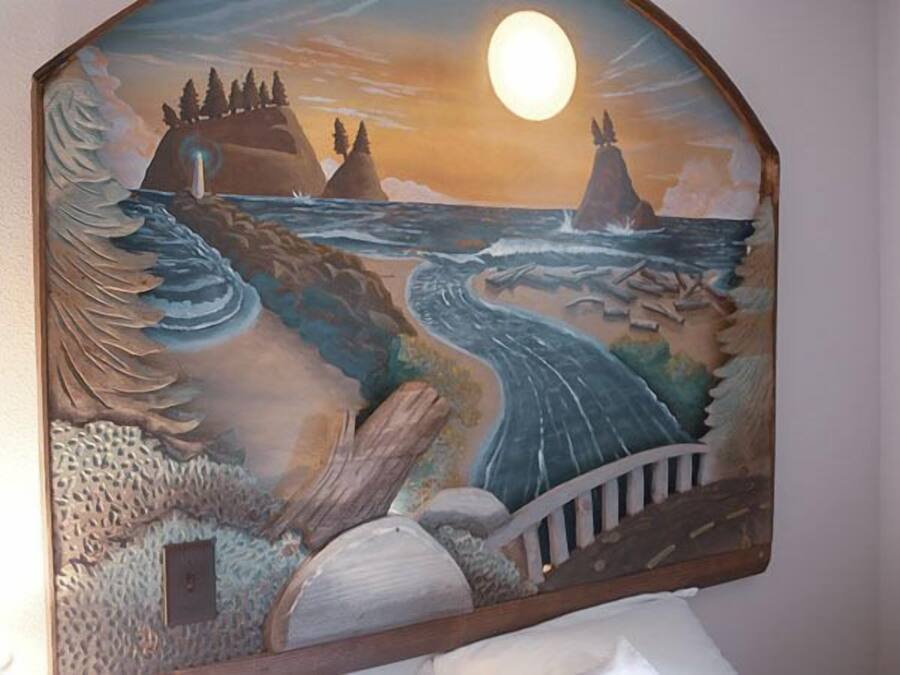 Um mural com uma cena costeira, incluindo um farol, ondas e uma ponte.