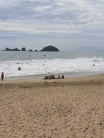 Na praia, guarda-sóis de praia, toalhas de praia, voleibol de praia 