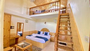 Quarto com cama de madeira, escrivaninha, espelho e escada.