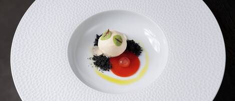 Um prato branco com sobremesa em uma mesa de madeira escura.
