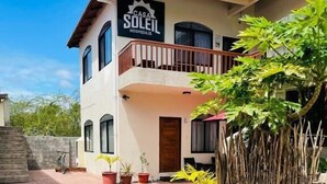 Um edifício de dois andares com uma placa que diz 'Casa Soleil Hospedaje'.