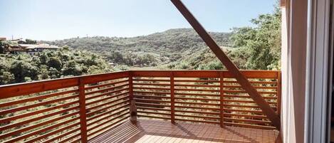 Um deck de madeira com vista para uma paisagem acidentada.
