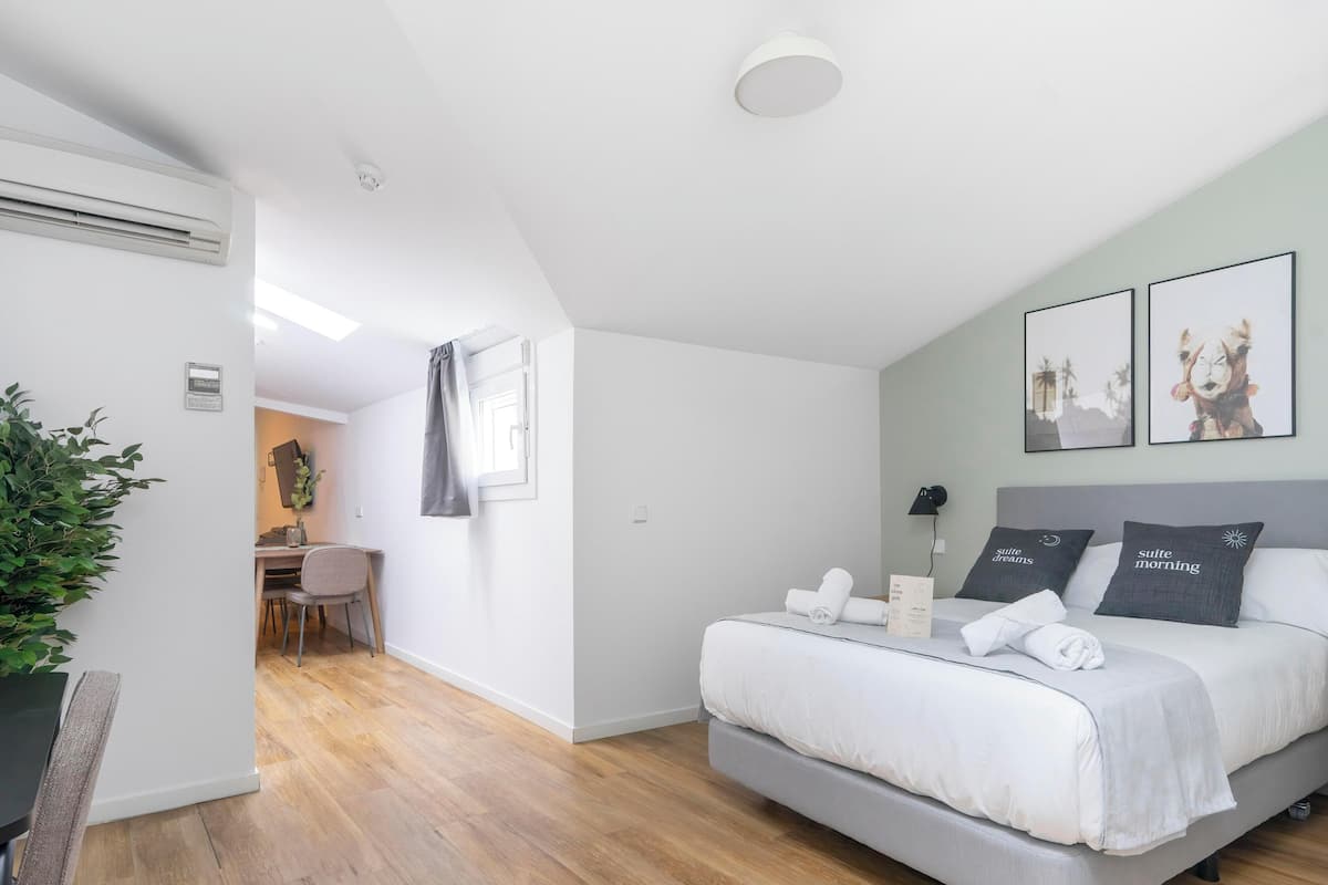 Quarto moderno com cama, mesas de cabeceira, escrivaninha e uma cadeira.