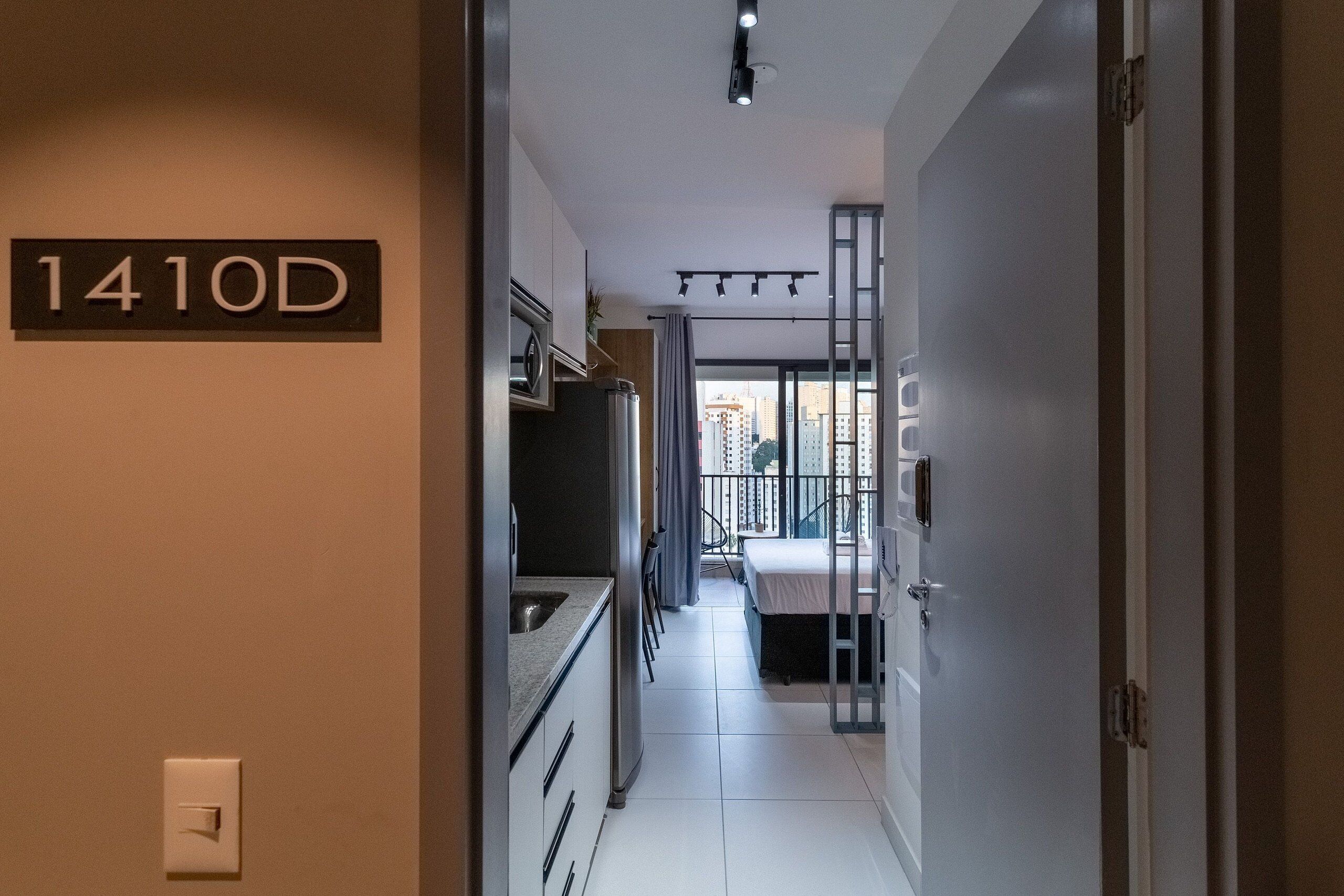 Um apartamento moderno com cozinha, varanda e vista, além de uma cama.