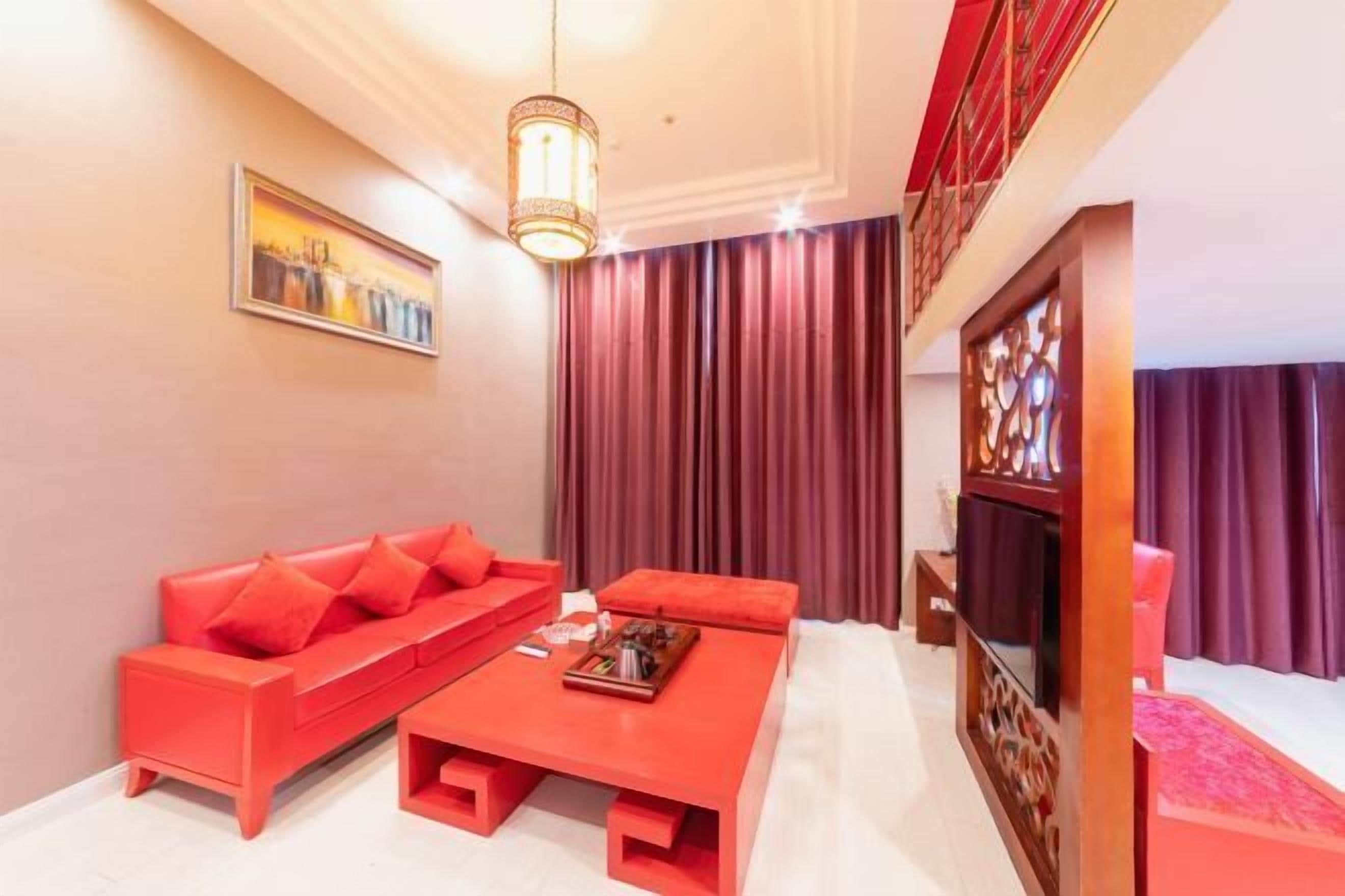 Uma sala de estar moderna com um sofá vermelho, uma mesa de centro e uma televisão.