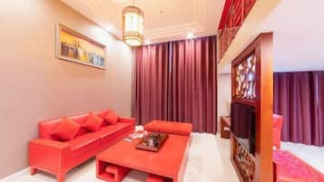 Uma sala de estar moderna com um sofá vermelho, uma mesa de centro e uma televisão.