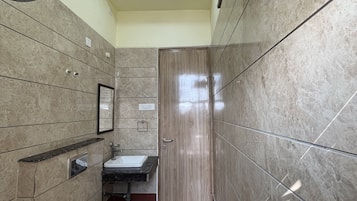 Casa de banho pequena com sanita, lavatório e chuveiro.