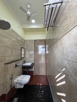 Casa de banho pequena com sanita, lavatório e chuveiro.