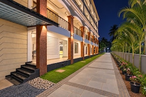 Um hotel com galeria coberta, área de estar externa e entrada bem iluminada.