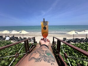 Na praia, praia de areia branca, espreguiçadeiras, guarda-sóis de praia 