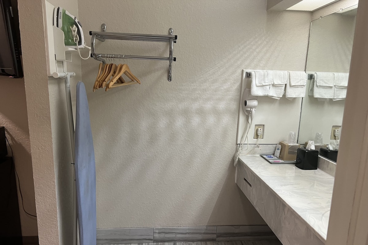 Casa de banho com um porta-toalhas, um secador de cabelo e um espelho.
