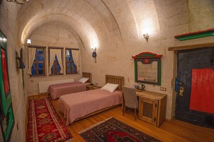 Quarto com duas camas, uma escrivaninha, uma cadeira e um guarda-roupa.