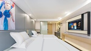 Quarto de hotel com duas camas, uma televisão e um cartaz grande na parede.