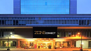 Um edifício moderno com uma fachada de vidro ampla e uma placa com a inscrição 'ZONECONNECT'.