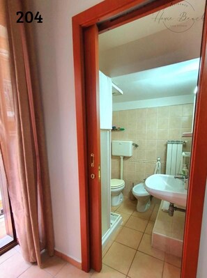 Casa de banho com sanita, bidé e lavatório.