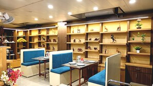 Restaurante com cabines, mesas e prateleiras com miniaturas de animais.