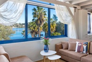 Apartamento superluxo, 2 quartos, vista para o mar | Sala de estar | Smart TV 32 polegadas com canais via satélite, TV, Netflix