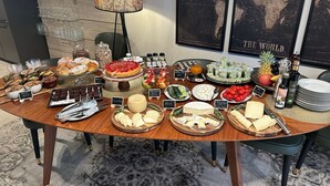 Uma mesa de buffet com diversos alimentos e um mapa mundi ao fundo.