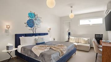 Um quarto moderno com uma cama grande, mesas de cabeceira, uma escrivaninha e uma cadeira.