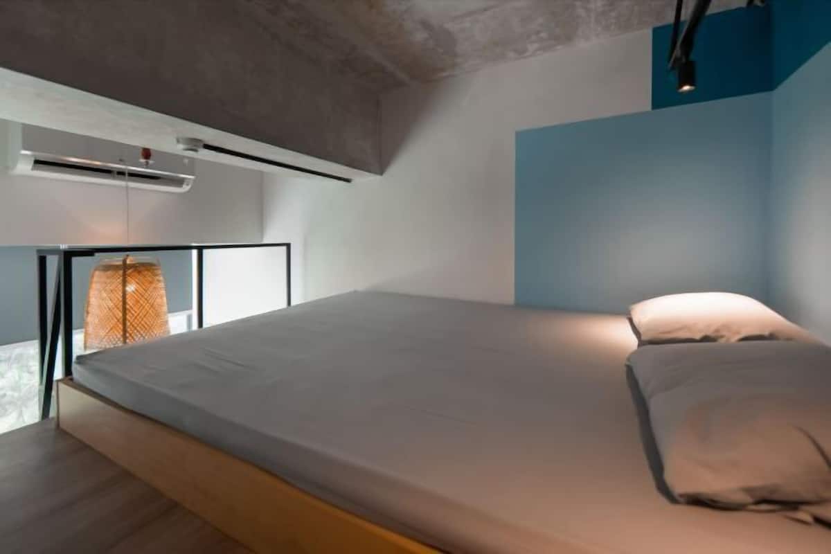 Quarto moderno com cama, ar condicionado e vista pela janela.
