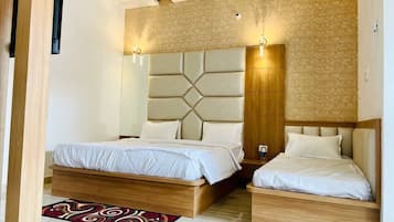 Quarto moderno com duas camas, um painel decorativo e um tapete estampado.