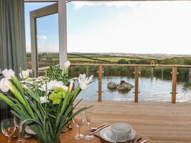 Mesa de jantar com vista para um lago e zona rural.