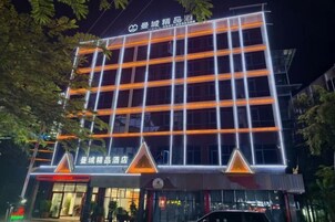 Um hotel com vários andares, fachada moderna, sinalização iluminada e entrada destacada.