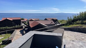 Vista costeira com edifícios de pedra e céu azul límpido.
