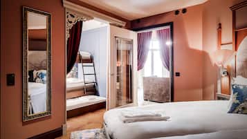 Quarto com uma cama grande, guarda-roupa, espelho e janela com cortinas.