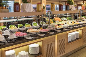 Um buffet com diversos alimentos e acompanhamentos.