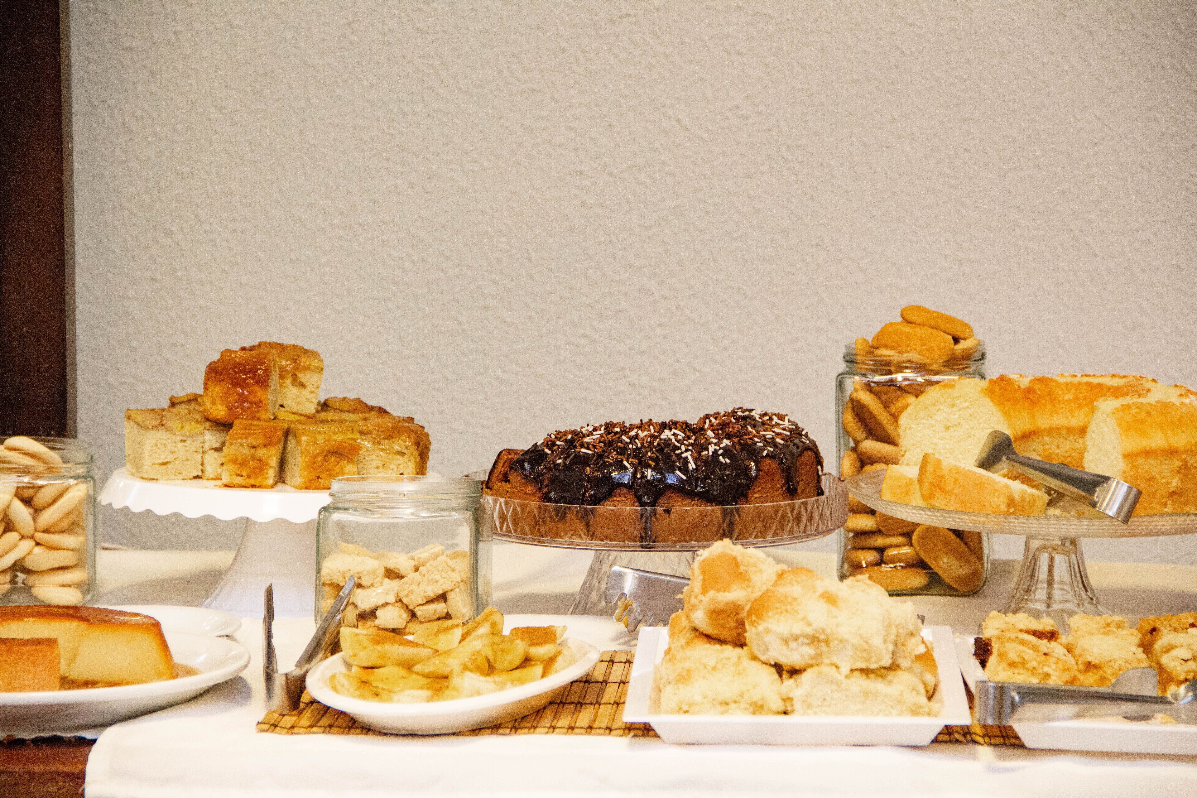 Uma mesa de buffet com diversos doces e pâtisseries.