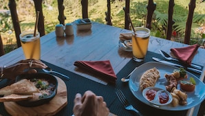 Uma mesa de jantar com comida, bebidas e uma vista panorâmica.