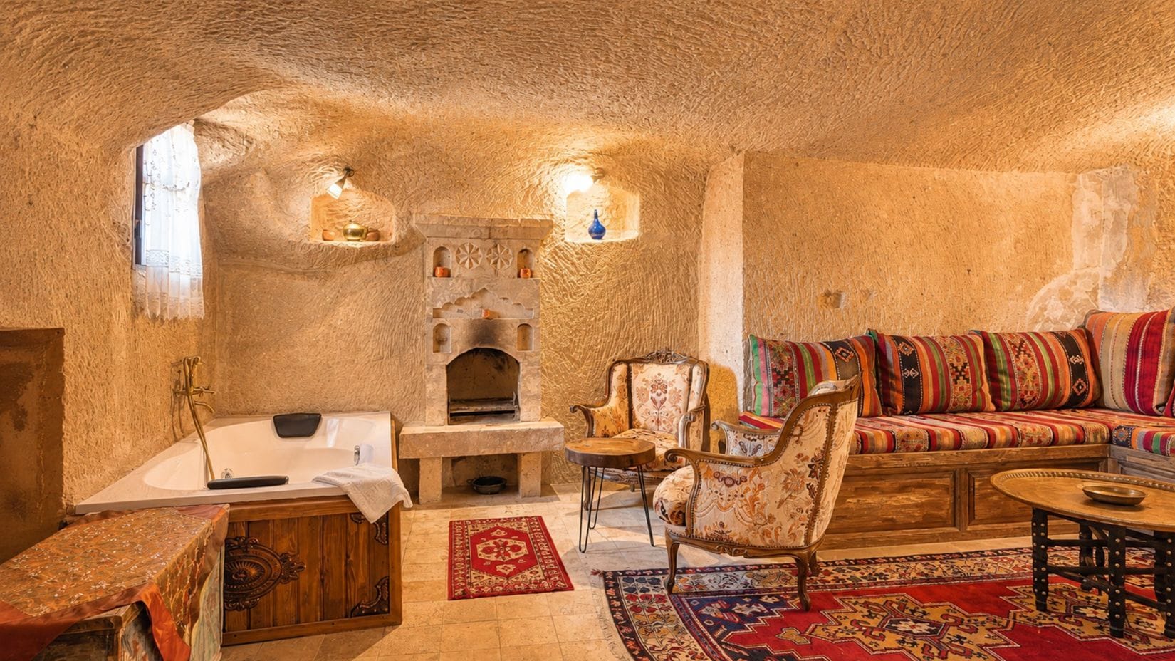 Um interior acolhedor com lareira de pedra, um sofá com almofadas coloridas e um armário de madeira.