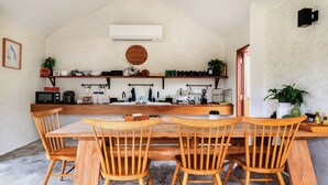 Cozinha com móveis de madeira, ar condicionado branco e diversos eletrodomésticos.