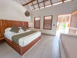 Quarto com estrutura de cama de madeira, roupa de cama branca e luminária pendente trançada.