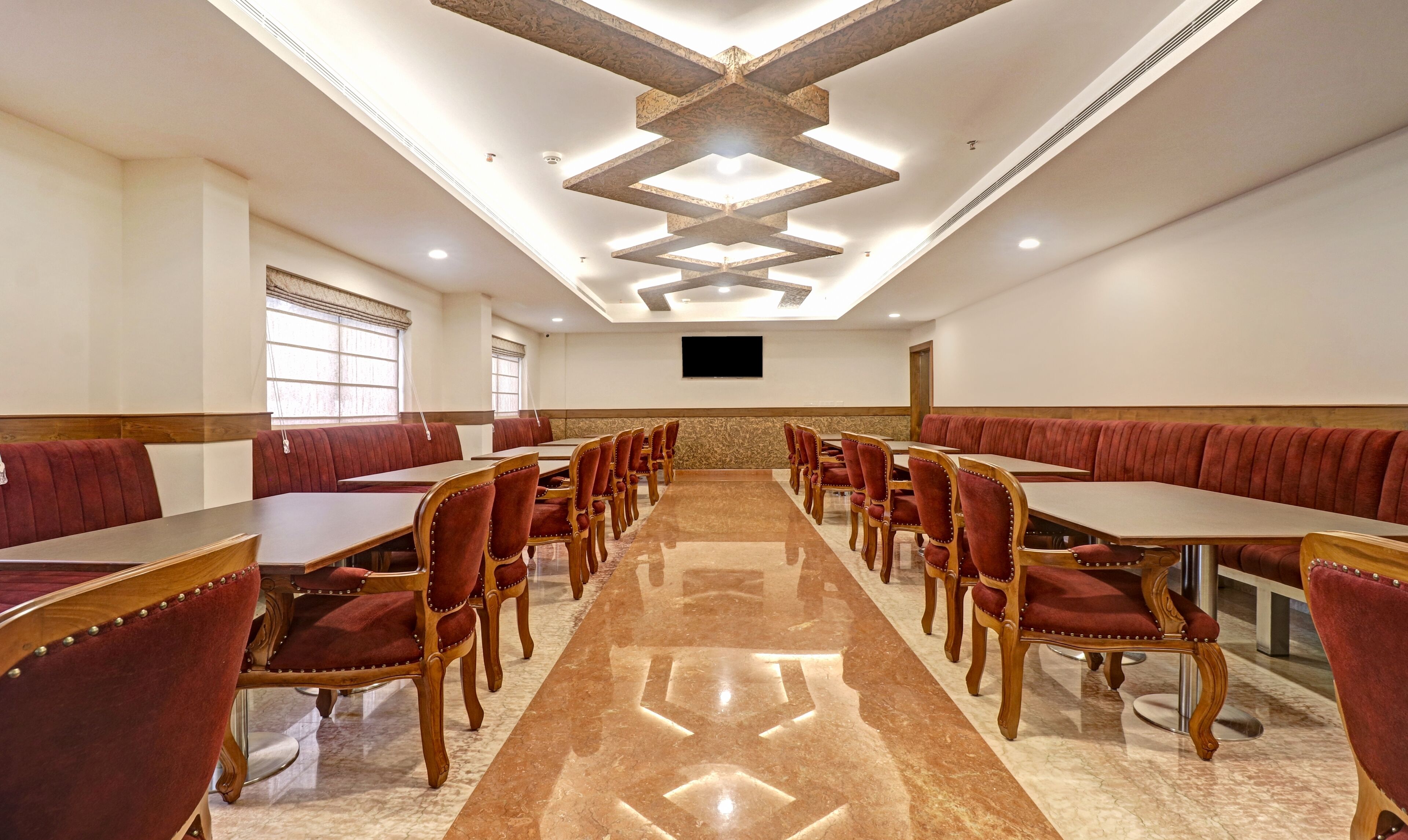 Uma sala de conferências com uma mesa comprida, assentos estofados em vermelho e cadeiras de madeira.