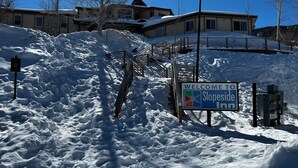 Paisagem coberta de neve com uma placa de boas-vindas ao Slopeside Inn.