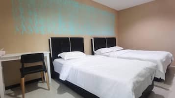 Quarto de hotel com duas camas de solteiro, uma escrivaninha com cadeira e um grande mural abstrato na parede.