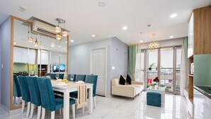 Uma sala de estar moderna com área de jantar, sofá e televisão.