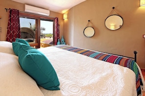 Quarto de hotel com uma cama, vista para o exterior e duas espelhos fixados na parede.