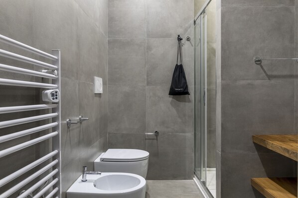 Uma casa de banho moderna com sanita, lavatório e cabine de duche em vidro.