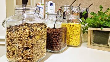 Três potes de vidro com diferentes tipos de cereal sobre uma mesa.