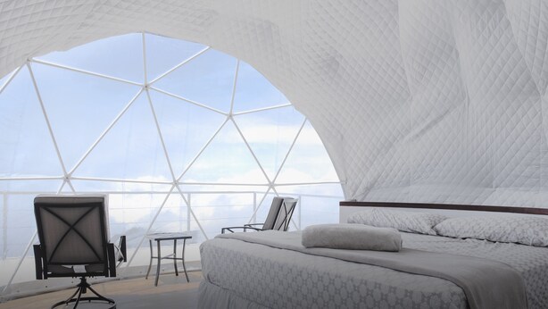 Quarto moderno e espaçoso, com uma grande janela em arco que oferece vista panorâmica.
