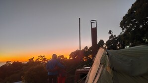 Tenda montada numa plataforma com vista para o pôr do sol.