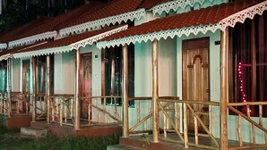 Uma fileira de edifícios em estilo tradicional, com grades e portas de madeira, provavelmente parte de um hotel ou resort.