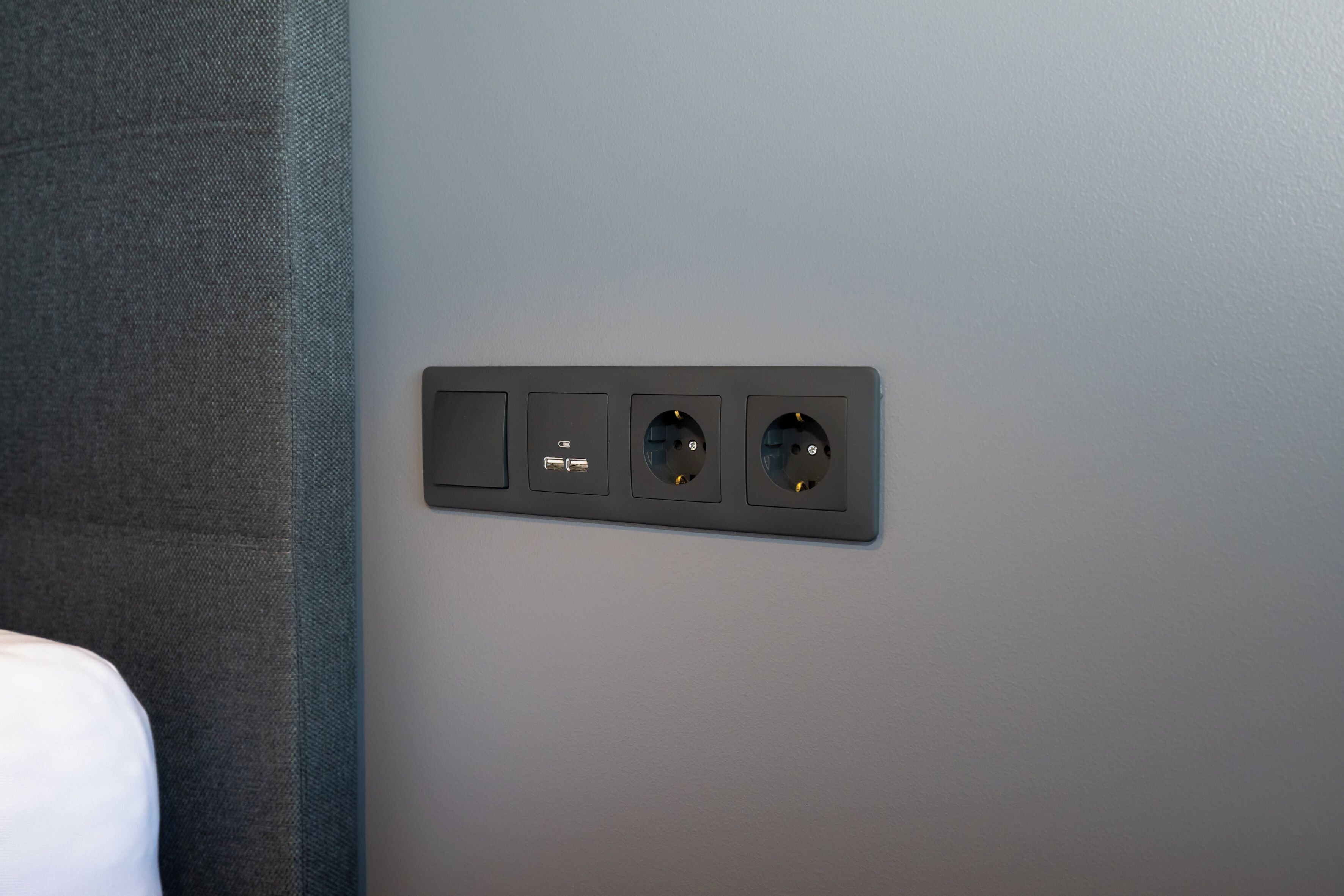 Tomada elétrica na parede com portas USB e uma tomada padrão.
