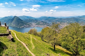 Vista panorâmica de uma paisagem montanhosa com um lago e uma cidade no vale.