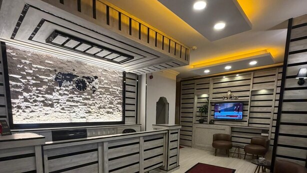 Sala de estar moderna com televisão, assentos e um tapete vermelho.