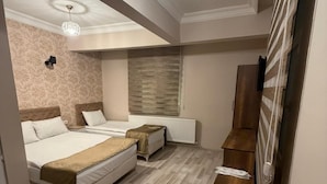 Quarto com cama, duas mesas de cabeceira, cômoda, radiador e lustre.