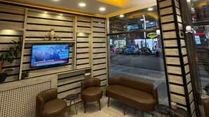 Um interior moderno com televisão, assentos e vista para a rua.